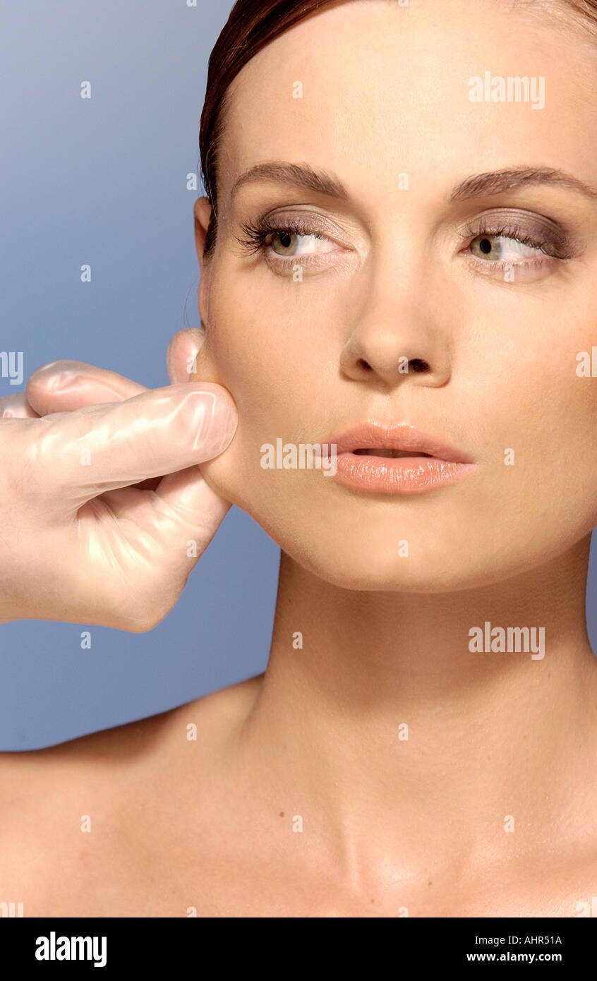 Surgeon pulling woman's skin Stock Photo - Alamy