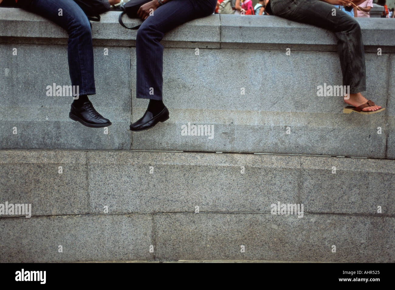 People sitting on wall Stock Photo - Alamy