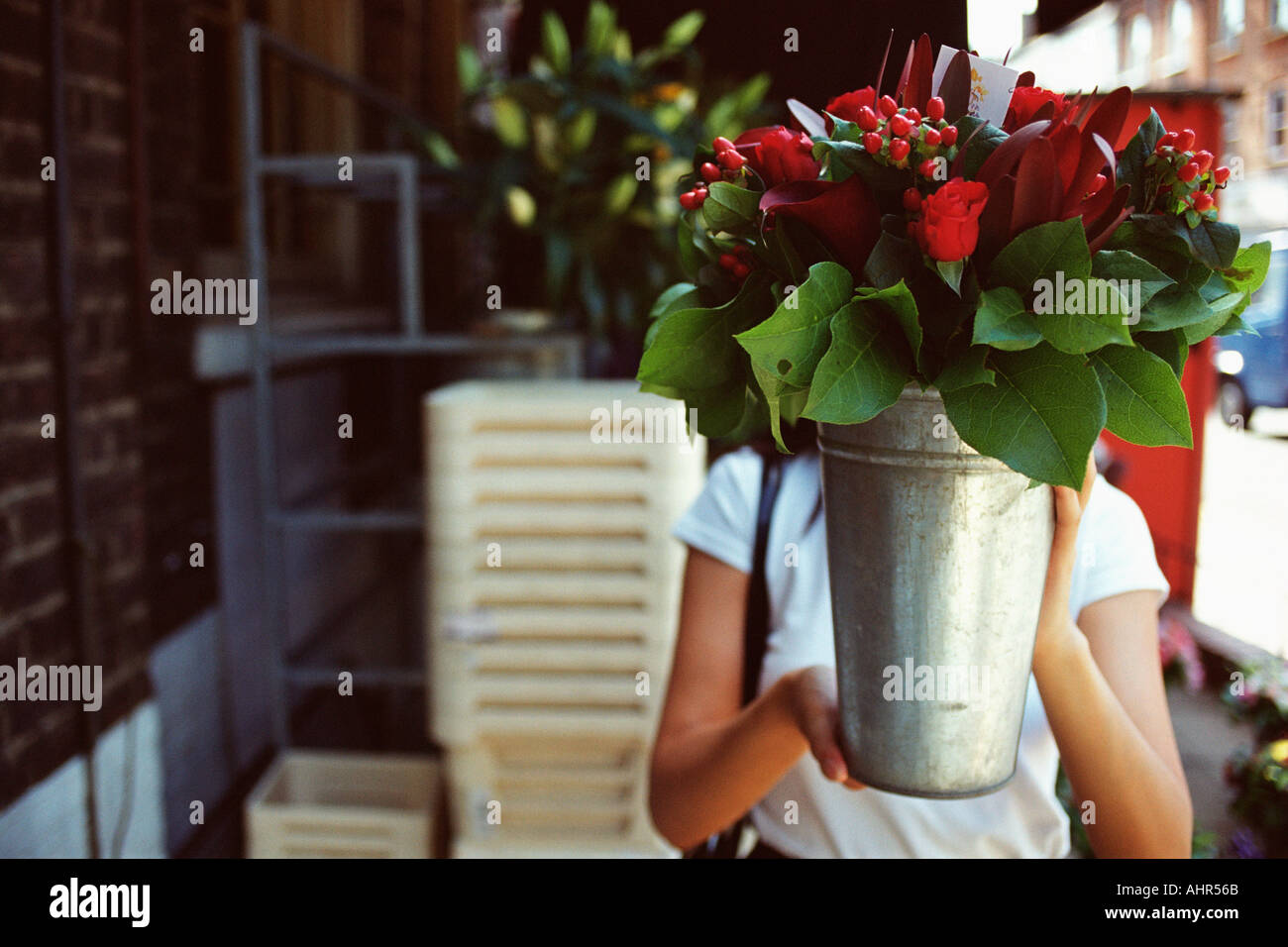 Woman holding a bucket of flowers Stock Photo - Alamy