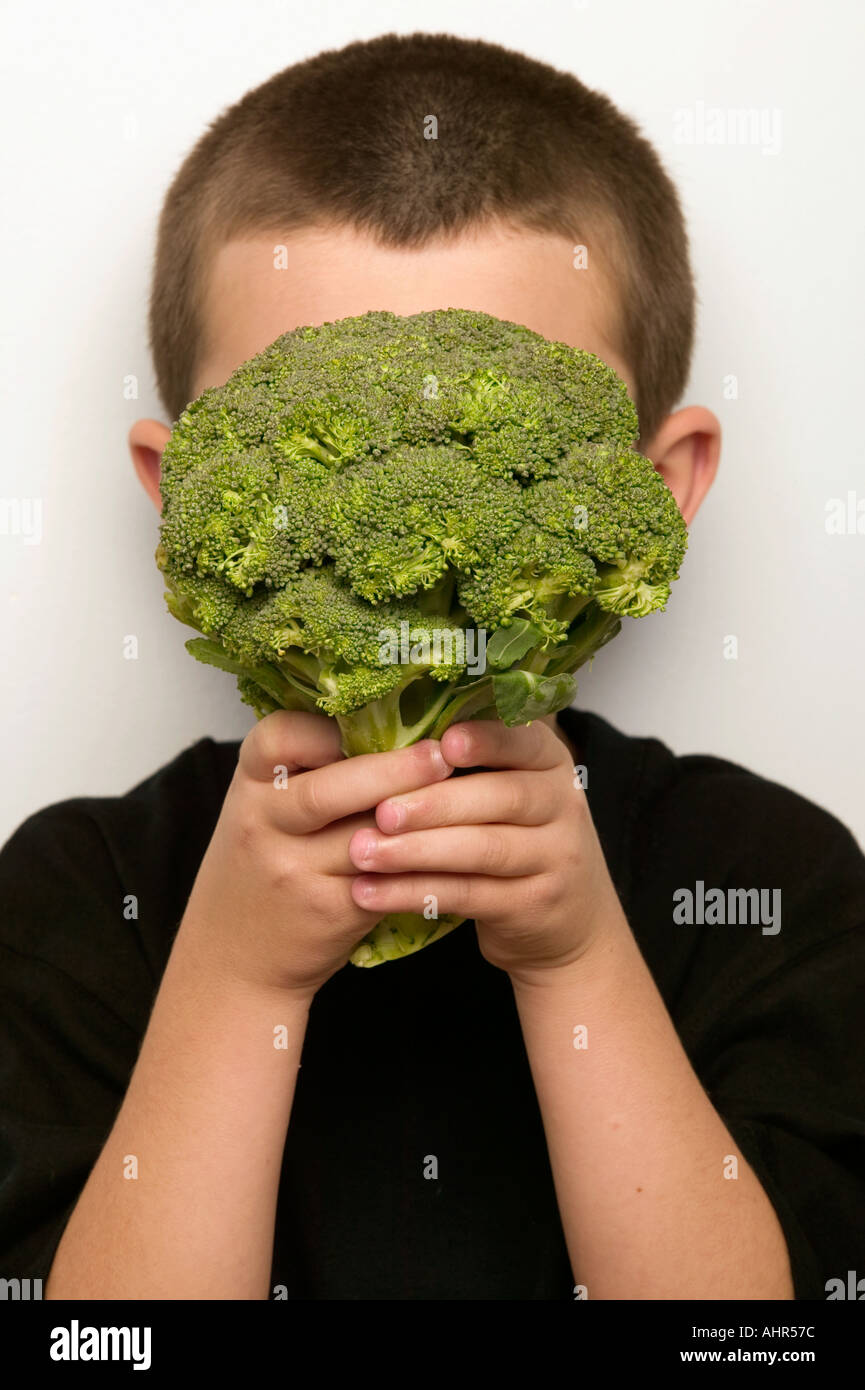 Boy covering face with broccoli Stock Photo - Alamy
