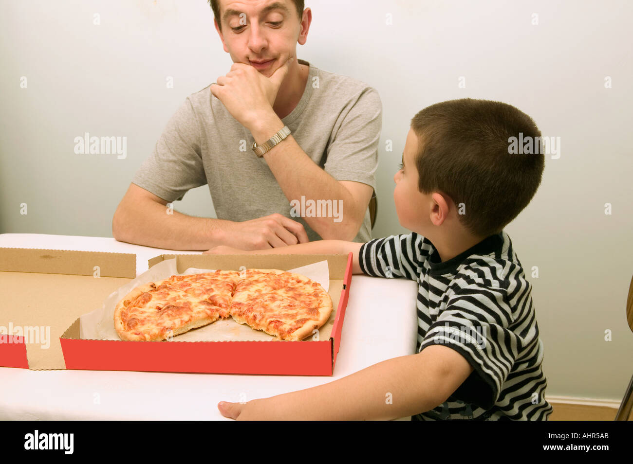 Father and son looking at a pizza Stock Photo - Alamy