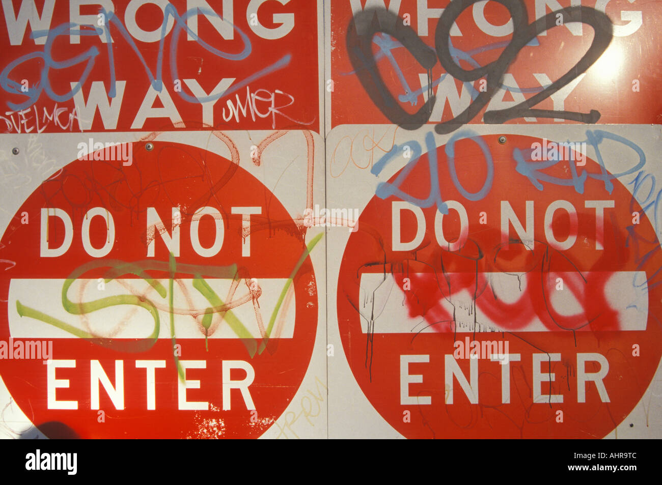 Red signs reading Wrong Way Do Not Enter covered with graffiti Los ...