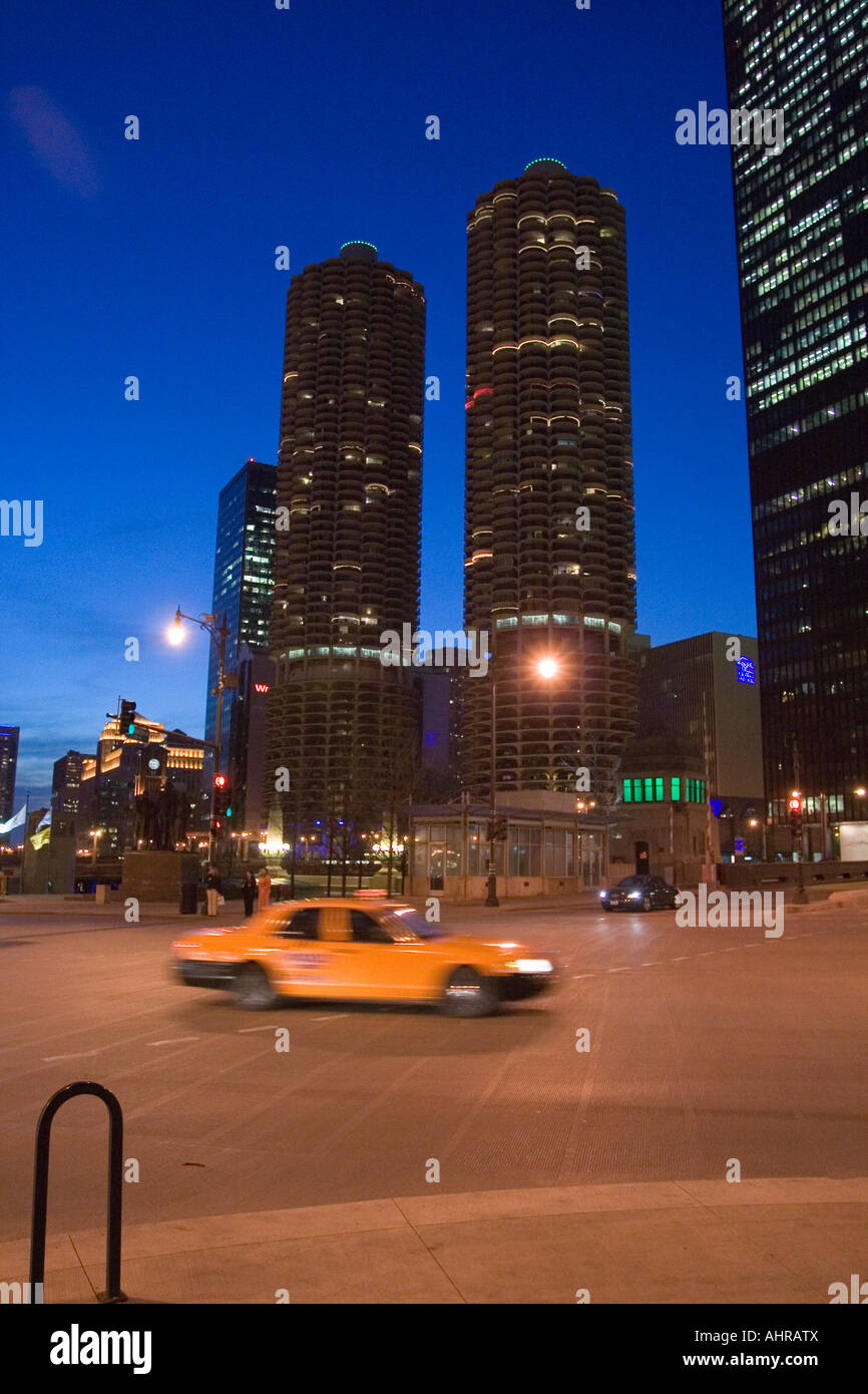Yellow Taxi Moving Through Urban Cityscape at Night with Skyscrapers ...