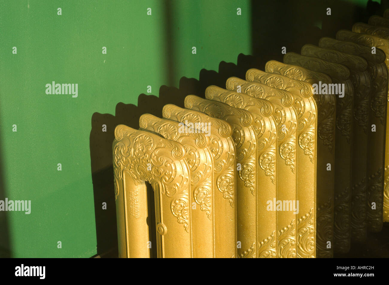 Gold colored radiator and green wall Stock Photo - Alamy