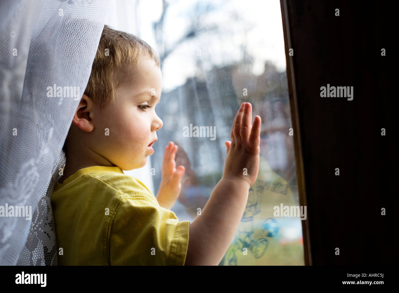 boy looking out of window Stock Photo - Alamy