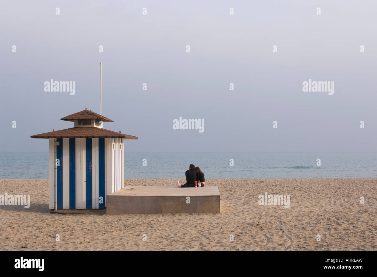 young couple sitting at the beach staring at the ocean Stock Photo - Alamy