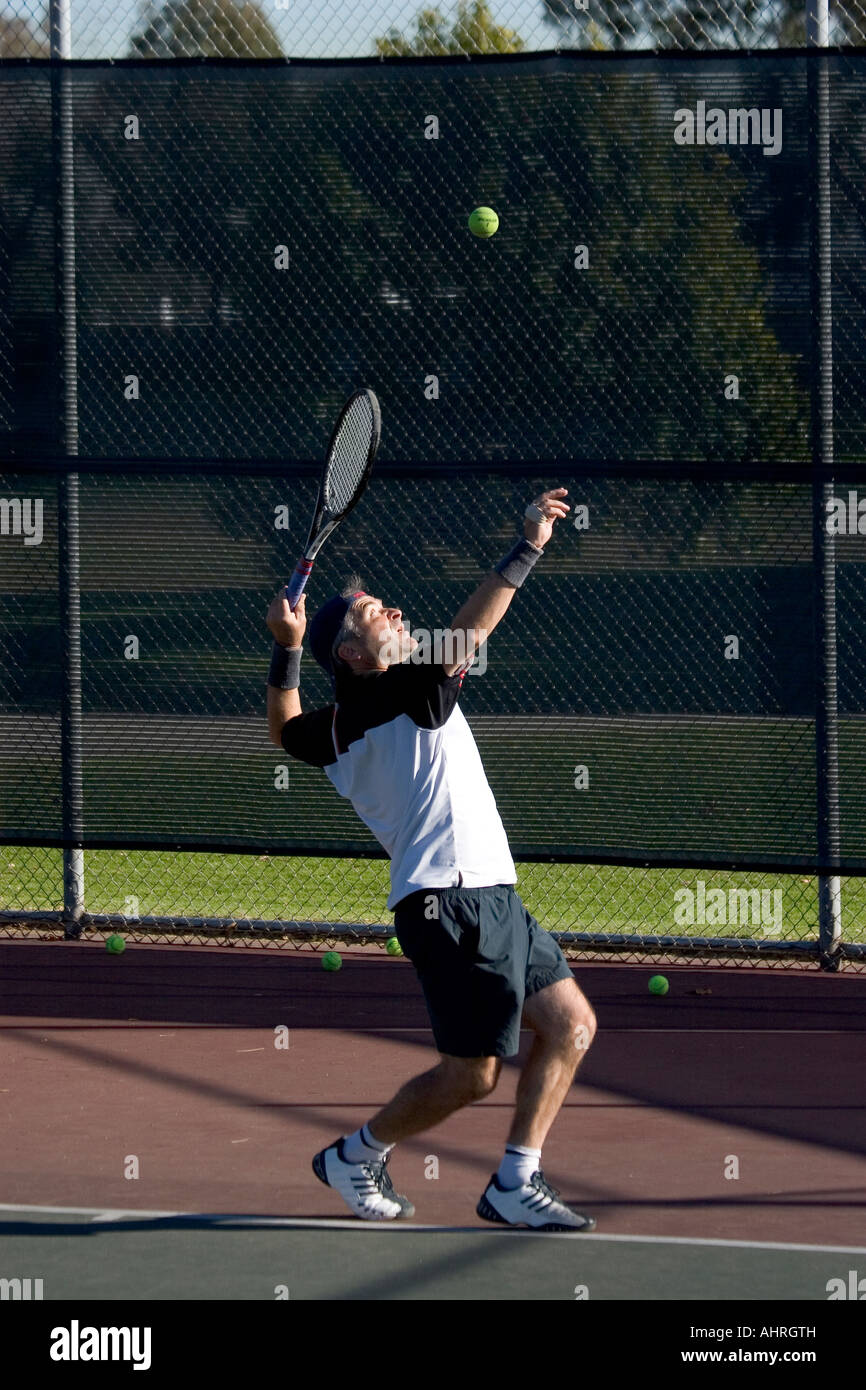 Tennis player serving the ball during a game Stock Photo - Alamy