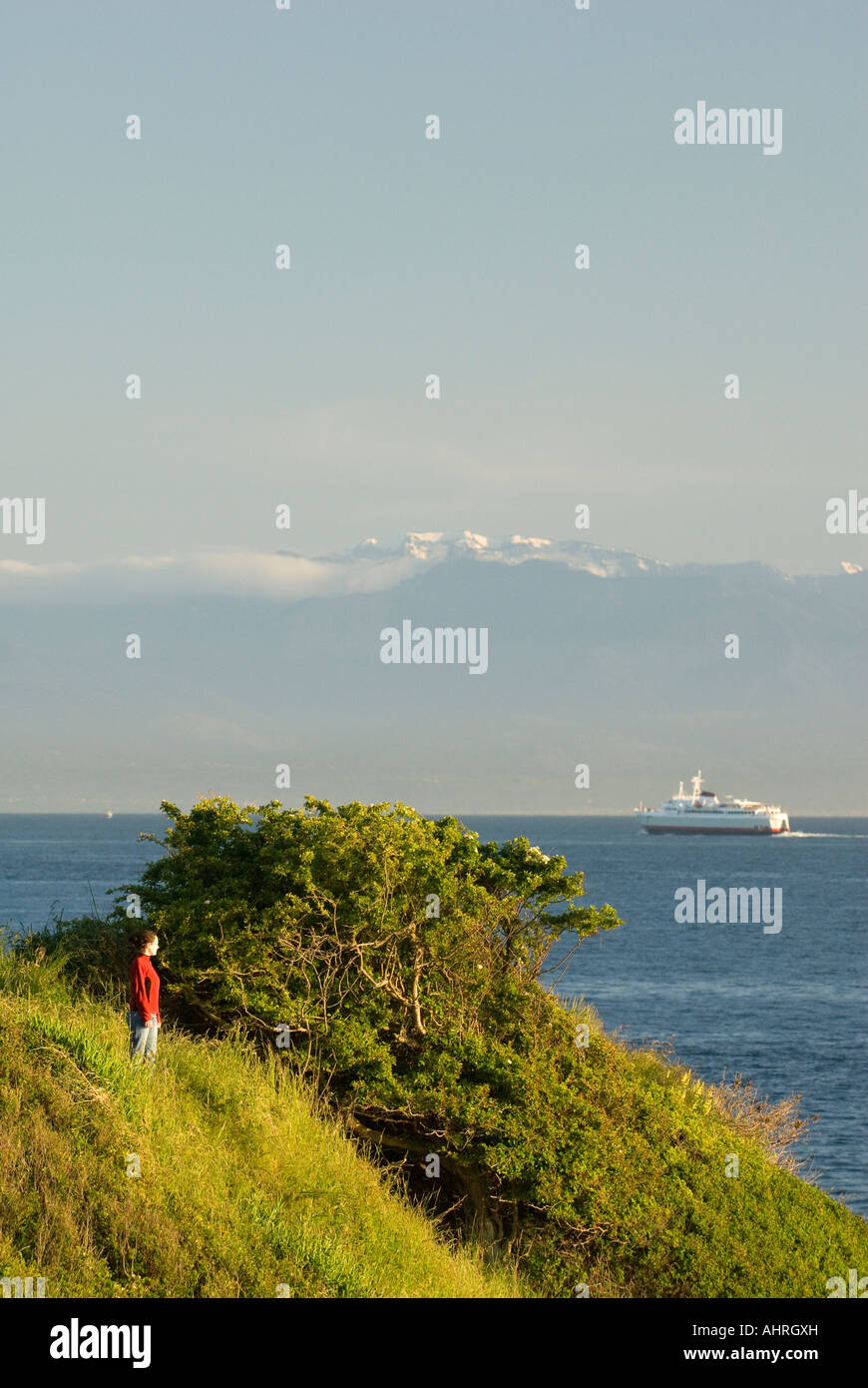 A woman enjoys the view from Victoria's Dallas Road waterfront with the ...