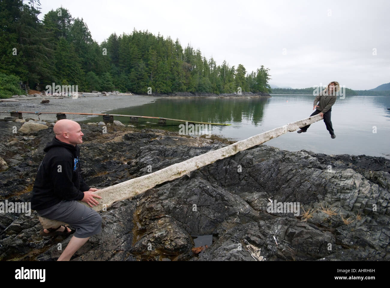 2 kayakers have fun on a drift log teeter totter Vargas Island BC Stock ...