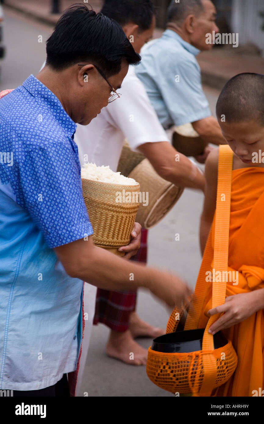 Local men give rice Alms to monks in Luang Prabang Laos Stock Photo - Alamy