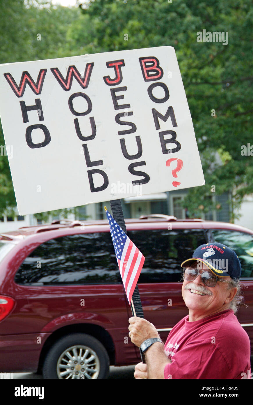 Protesters line a busy city street holding signs to protest war and ...