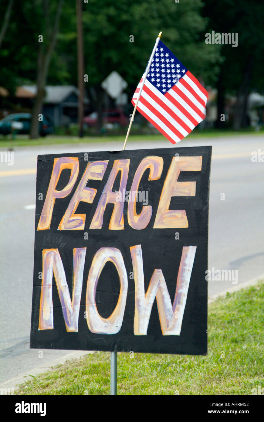 Protesters line a busy city street holding signs to protest war and ...