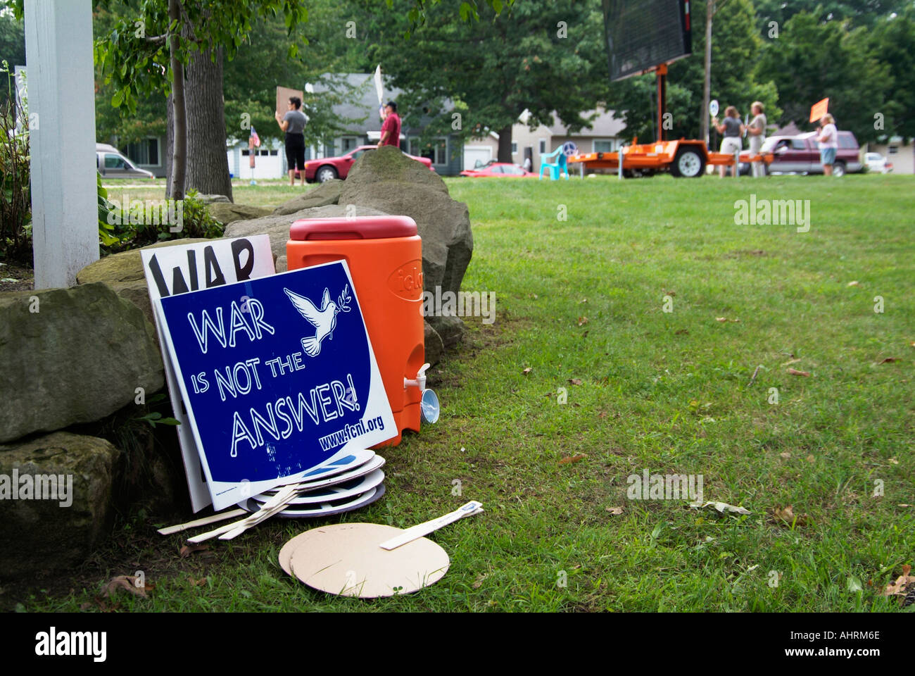 Protesters line a busy city street holding signs to protest war and ...
