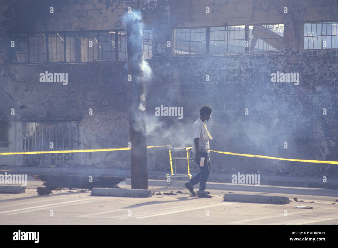 Man walking past burned industrial building after riots South Central ...