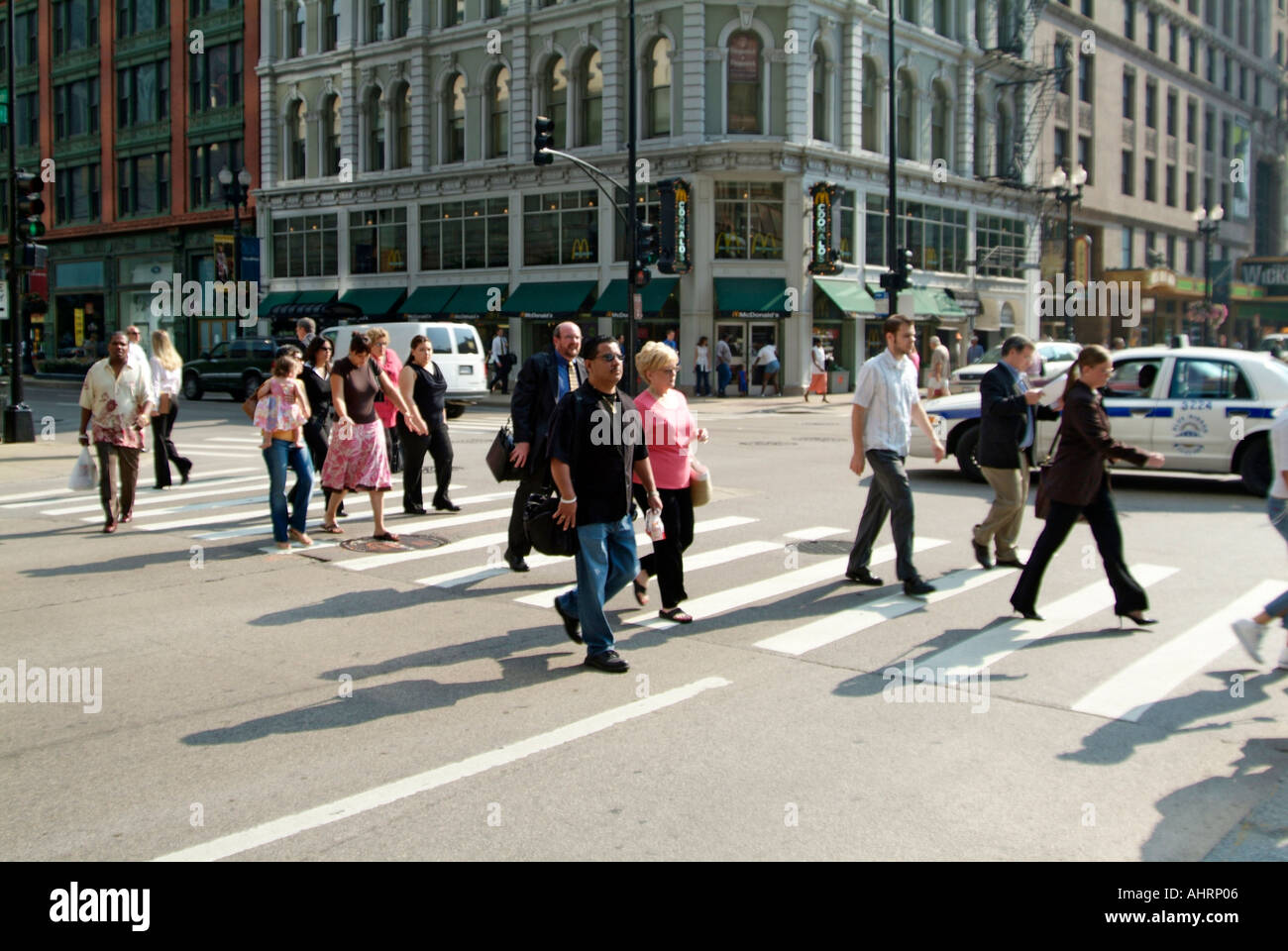 Crowds of people walking and crossing street at a traffic light in busy ...
