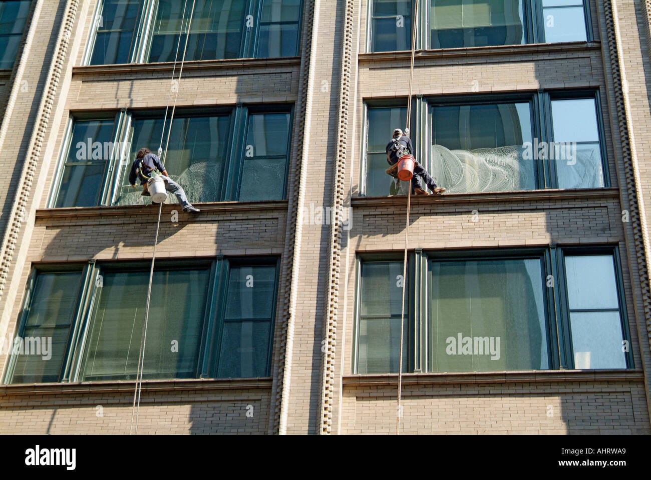 Window washers work at extreme heights to clean windows on tall ...