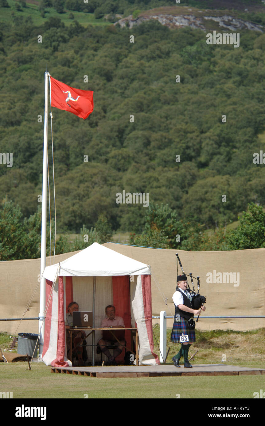 A lone piper and judges tent during competition at the Newtonmore ...