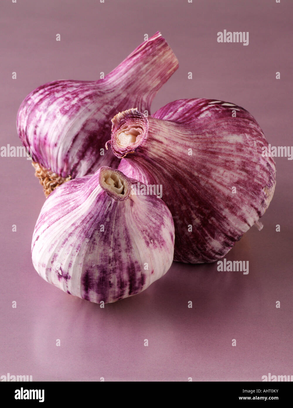 Three heads of purple garlic editorial food Stock Photo - Alamy