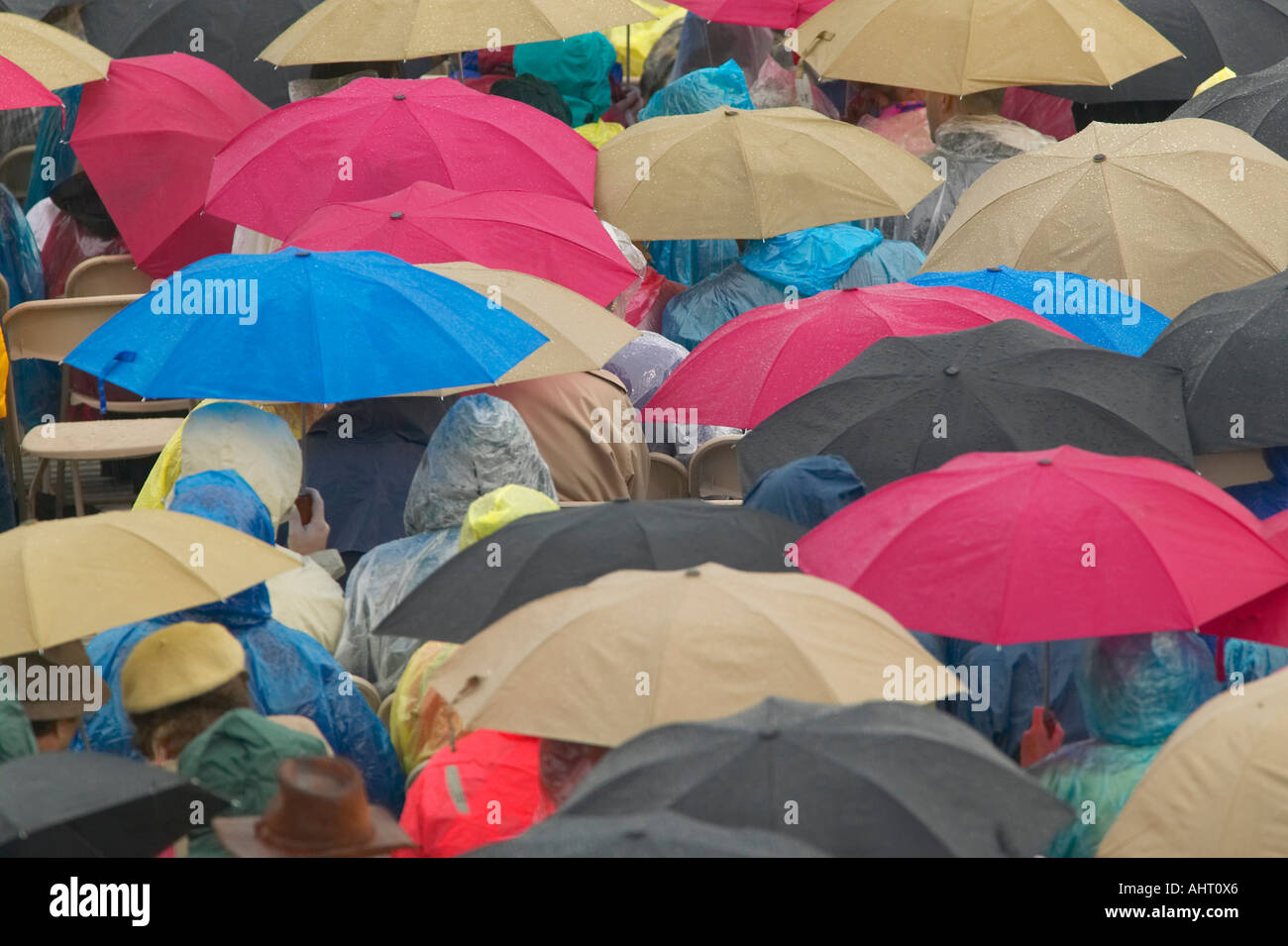 Guests hold umbrellas in the rain as they attend the official opening ...