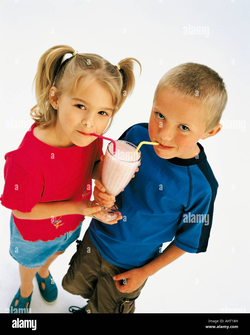 Boy and girl sharing a milkshake Stock Photo - Alamy