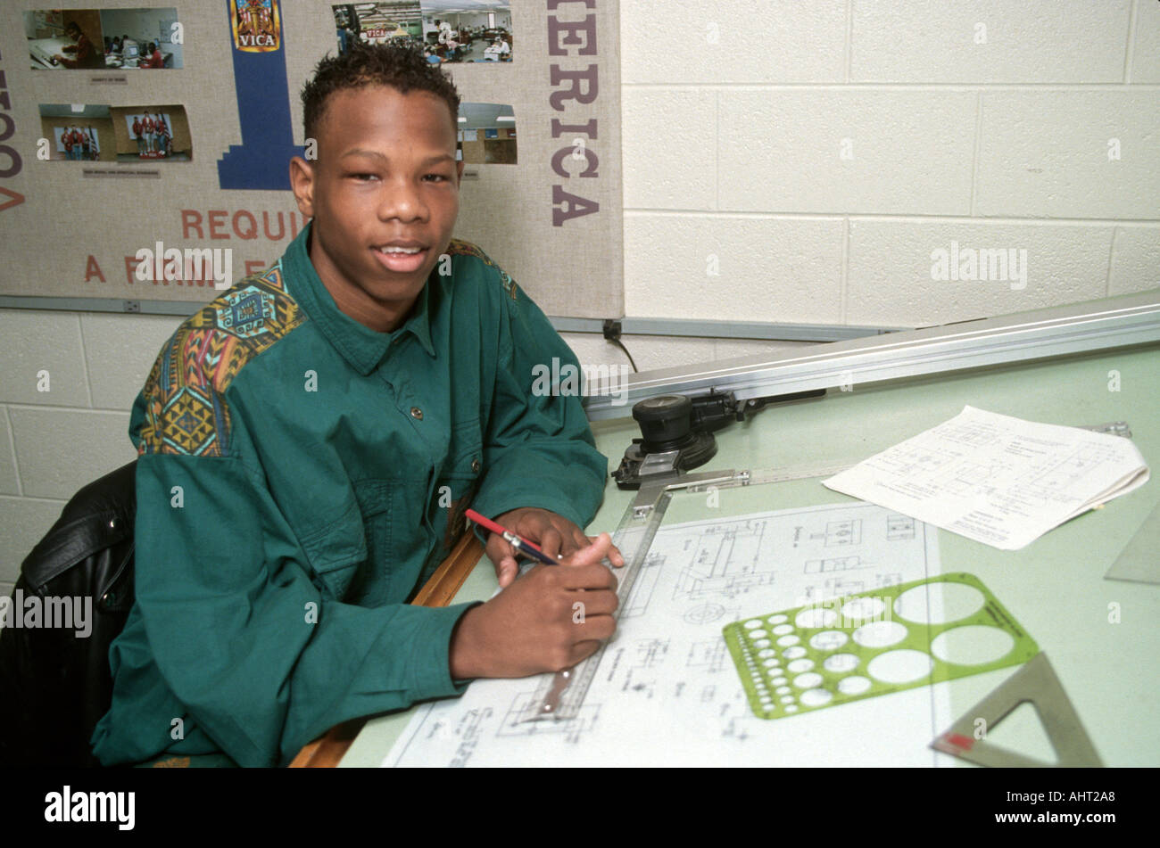 Black male high school student works at drawing in his drafting class ...