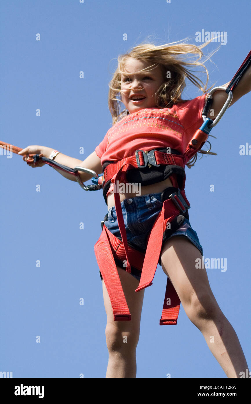 Cute little girl jumping on a bungee jump ride Stock Photo - Alamy