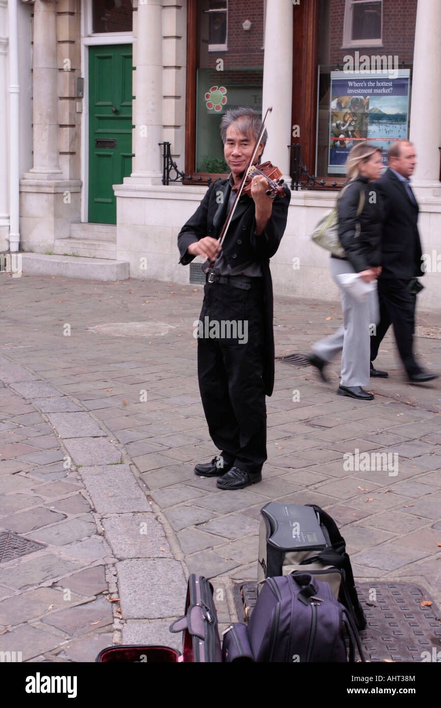 Adult male Busker playing violin in pedestrian precinct in Chichester ...