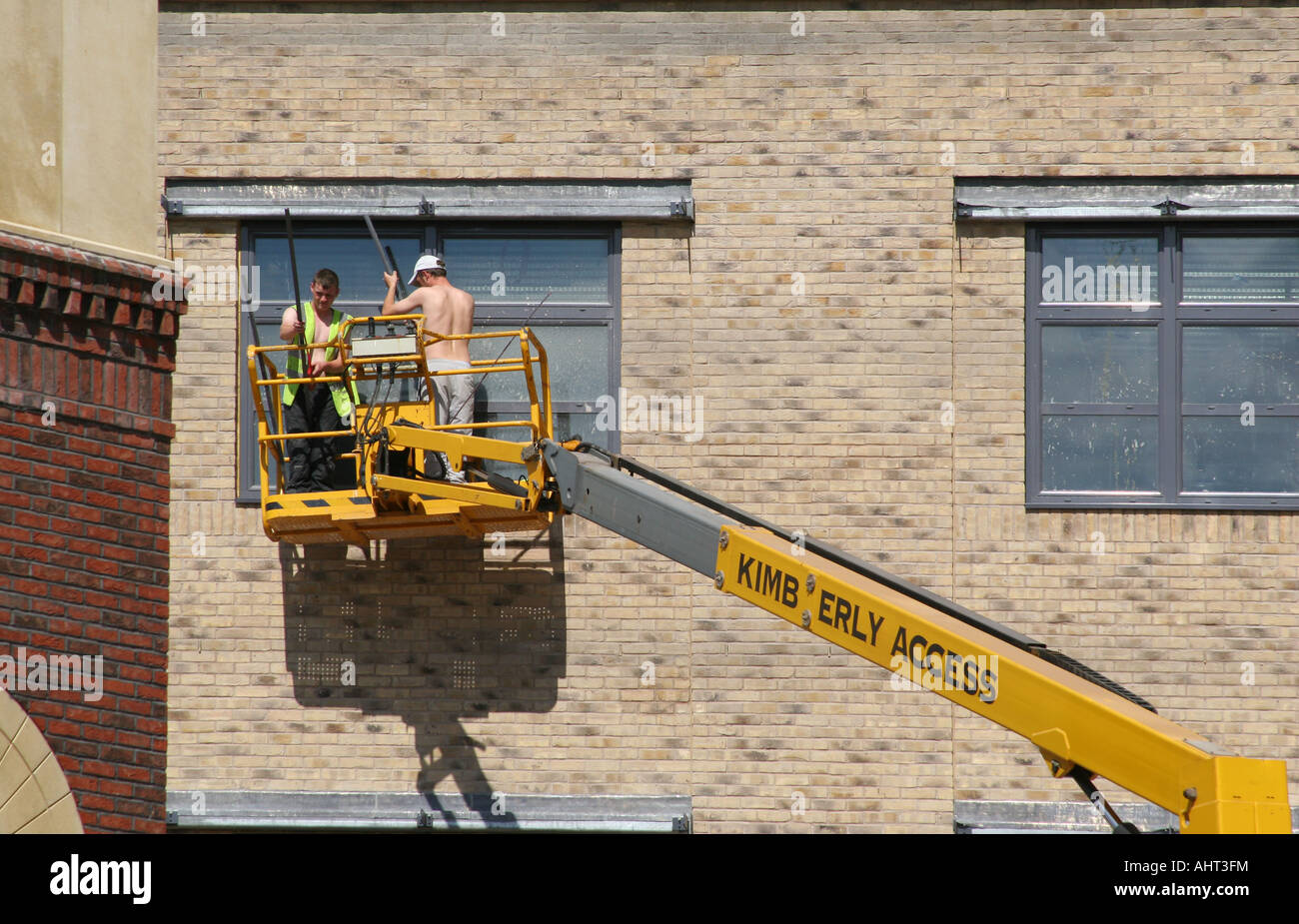Men in manlift basket working on a building window Stock Photo - Alamy