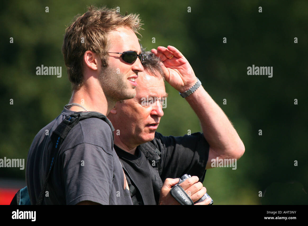 Two young men at a motor cycle racing meeting in close up with one ...