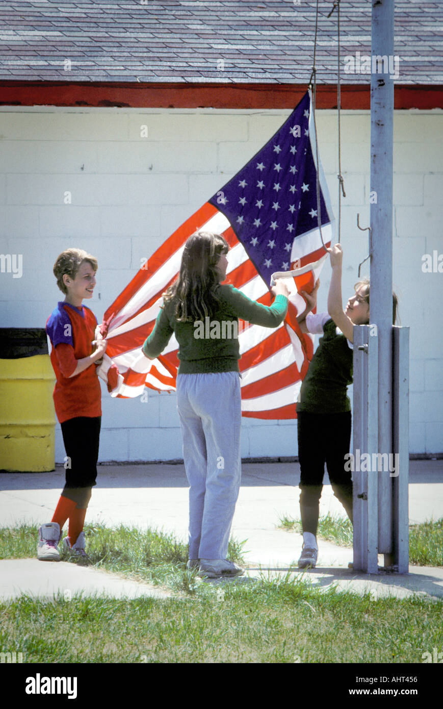 Group of children team up to raise the American flag Stock Photo - Alamy