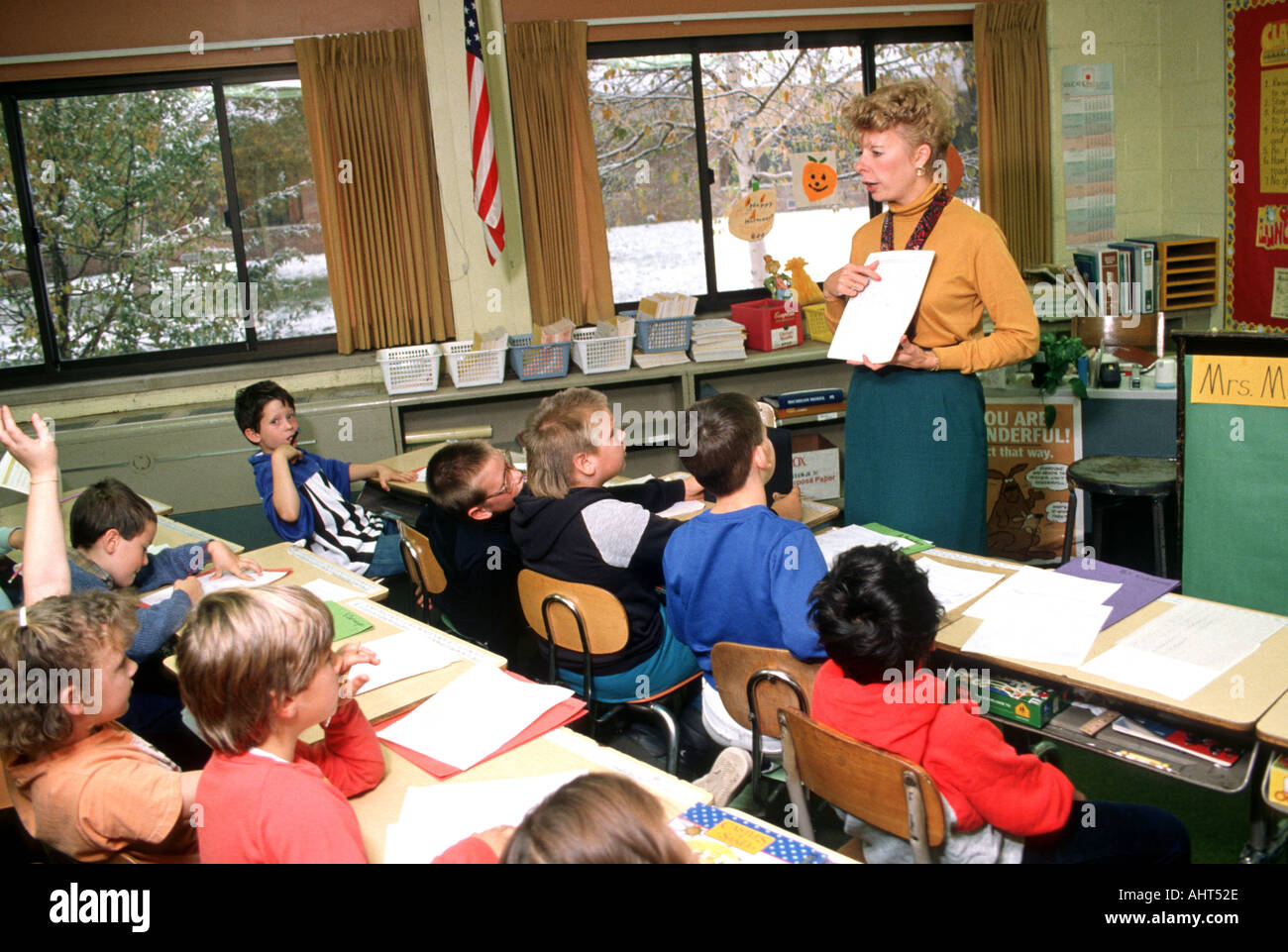 Female teacher stands in front of a 3rd grade class in a question and ...