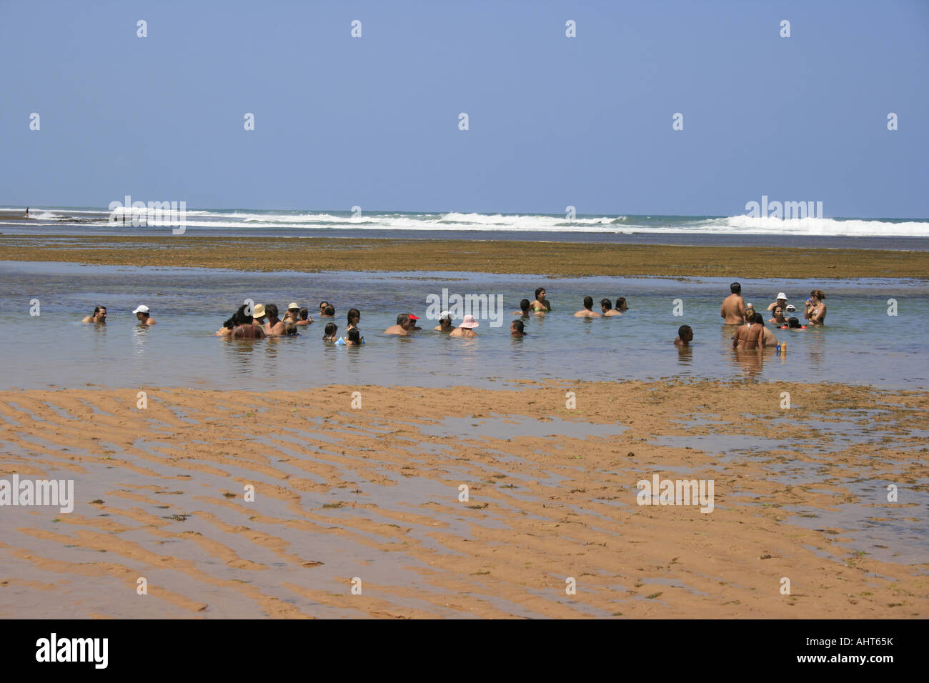 Tourists and locals bathing in the natural water pools at low tide in ...