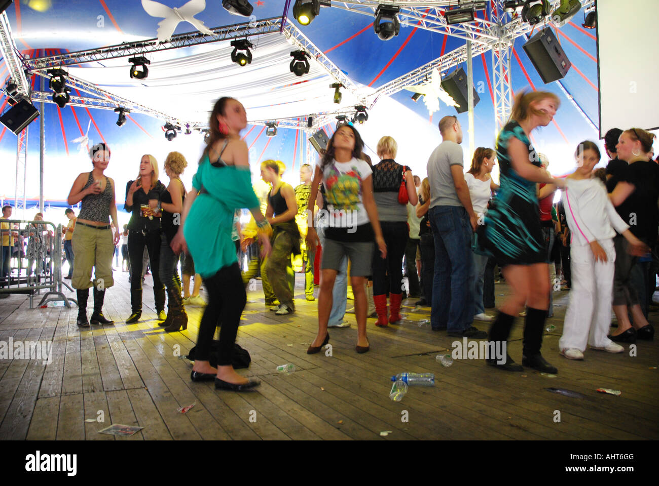 dancing crowd at dance festival in tent with stage lights and music ...