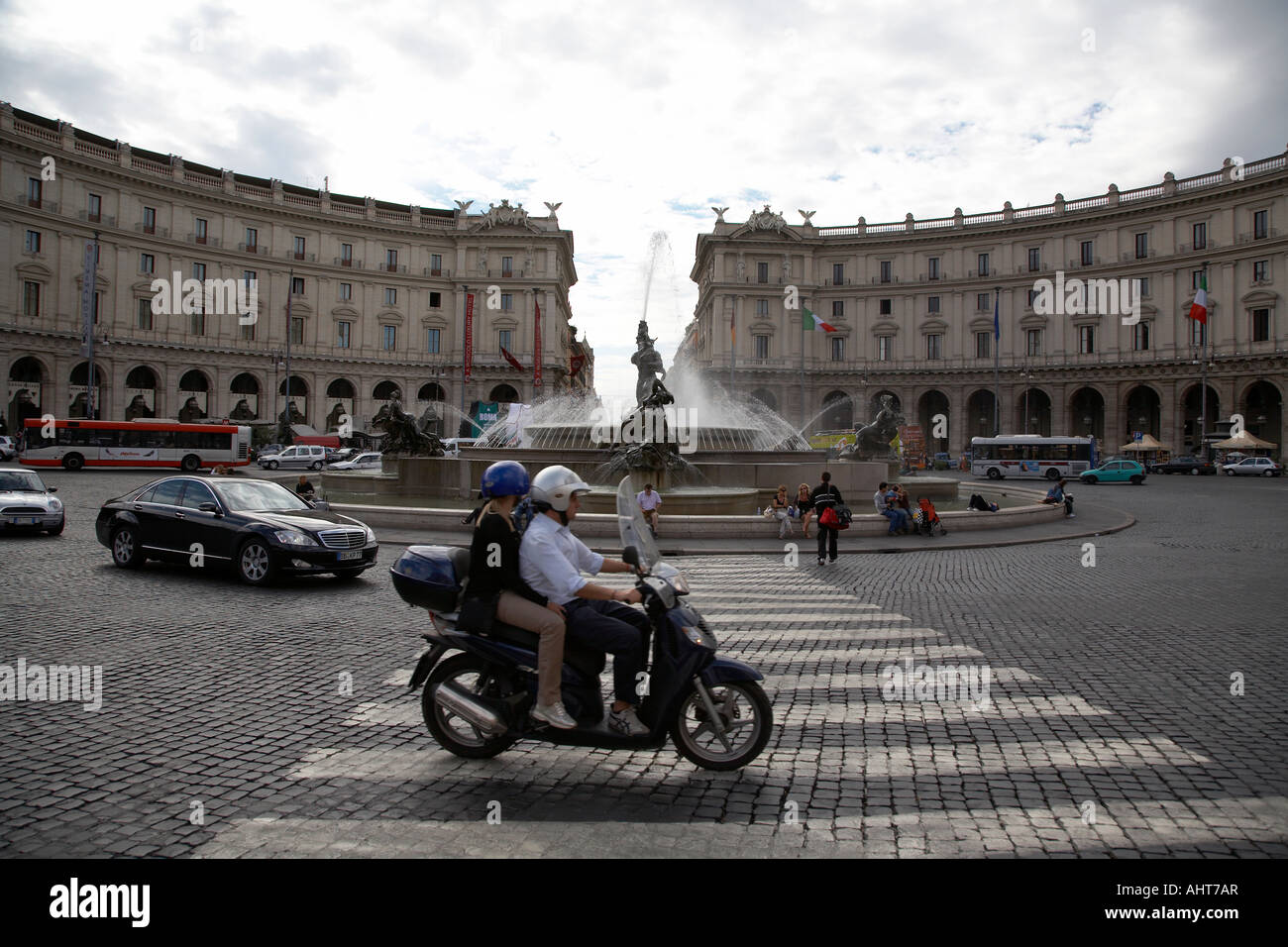 motor scooter with rider and pillion passenger crosses pedestrian ...