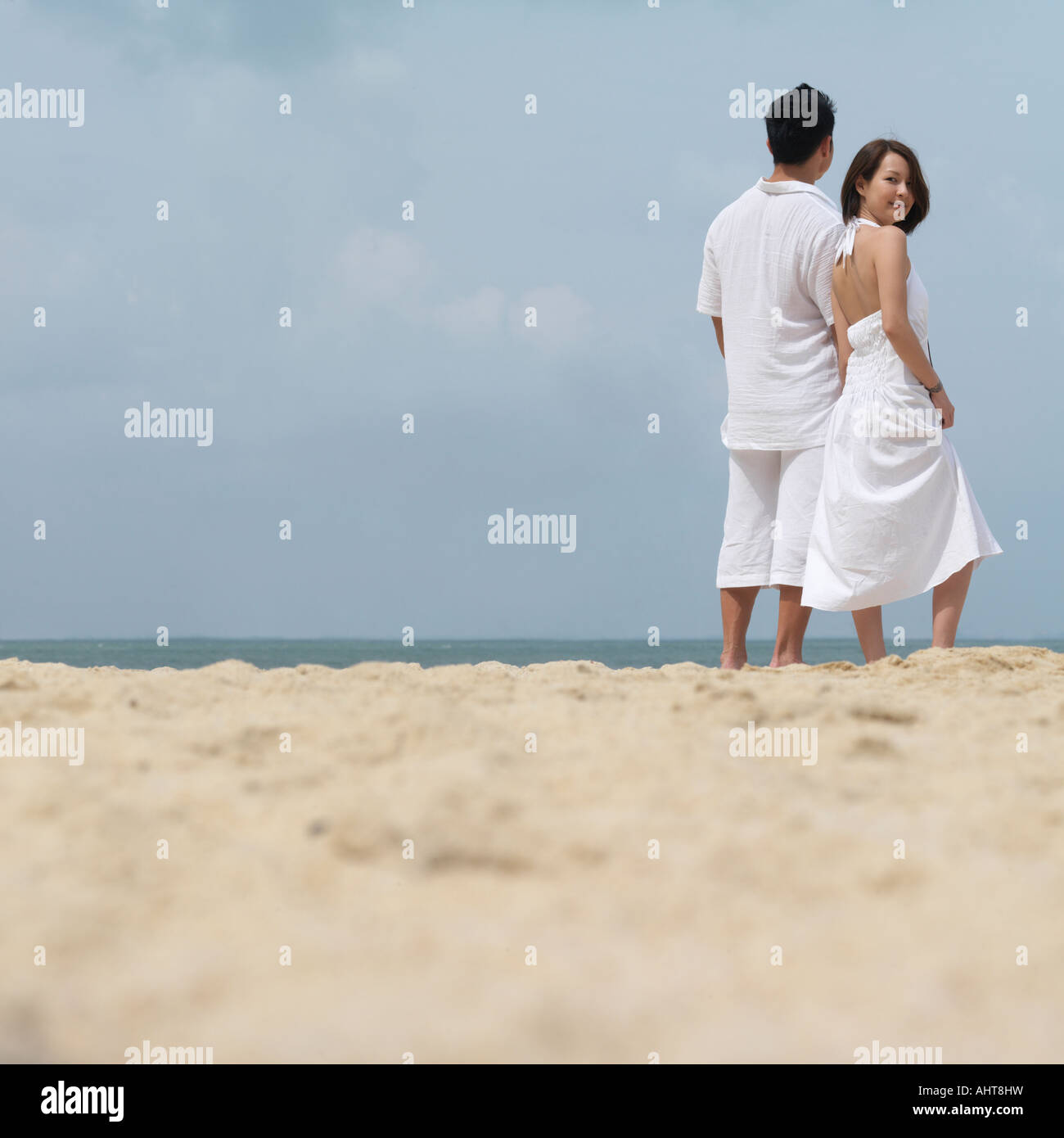 Couple standing by the beach, rear view Stock Photo - Alamy