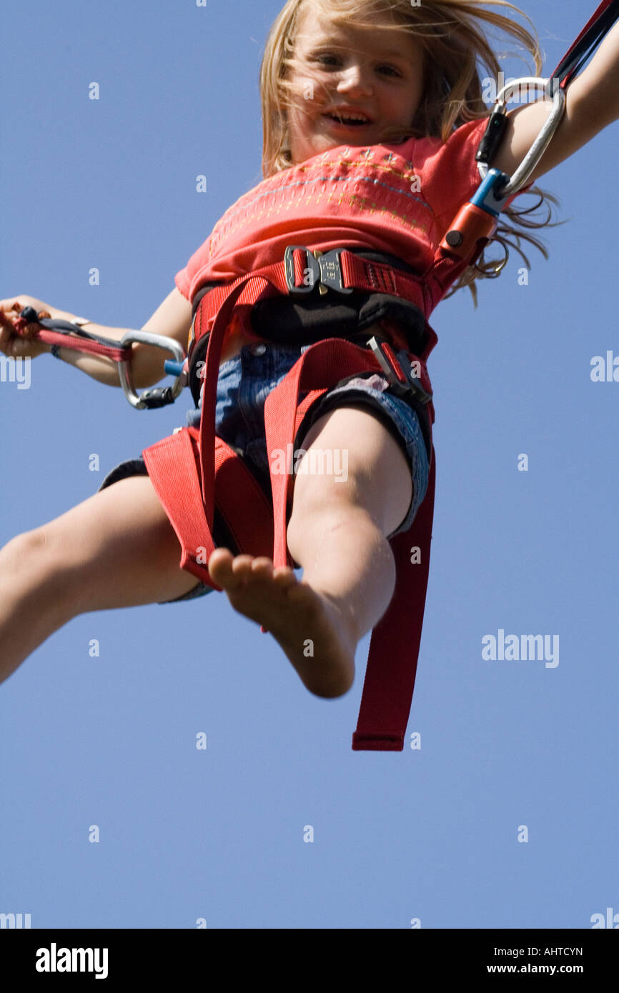 Cute little girl jumping on a bungee jump ride Stock Photo - Alamy