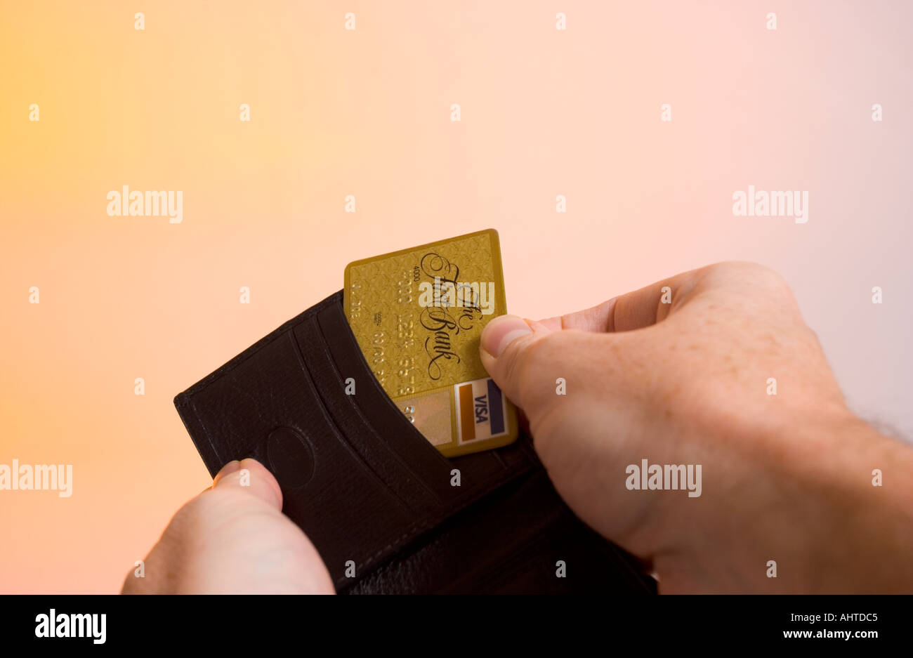 hand pulling a gold credit card from a wallet Stock Photo - Alamy