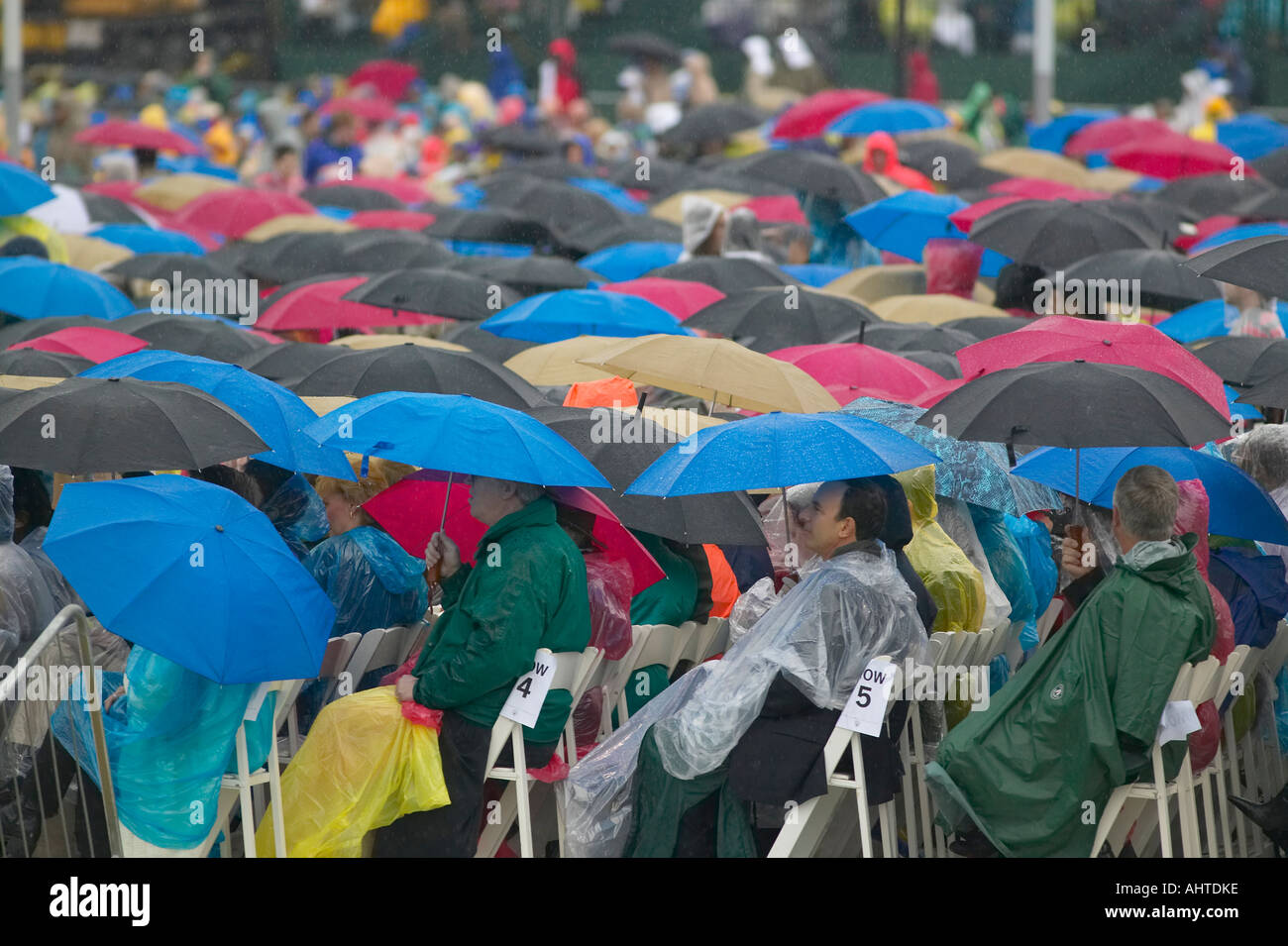 Guests hold umbrellas in the rain as they attend the official opening ...