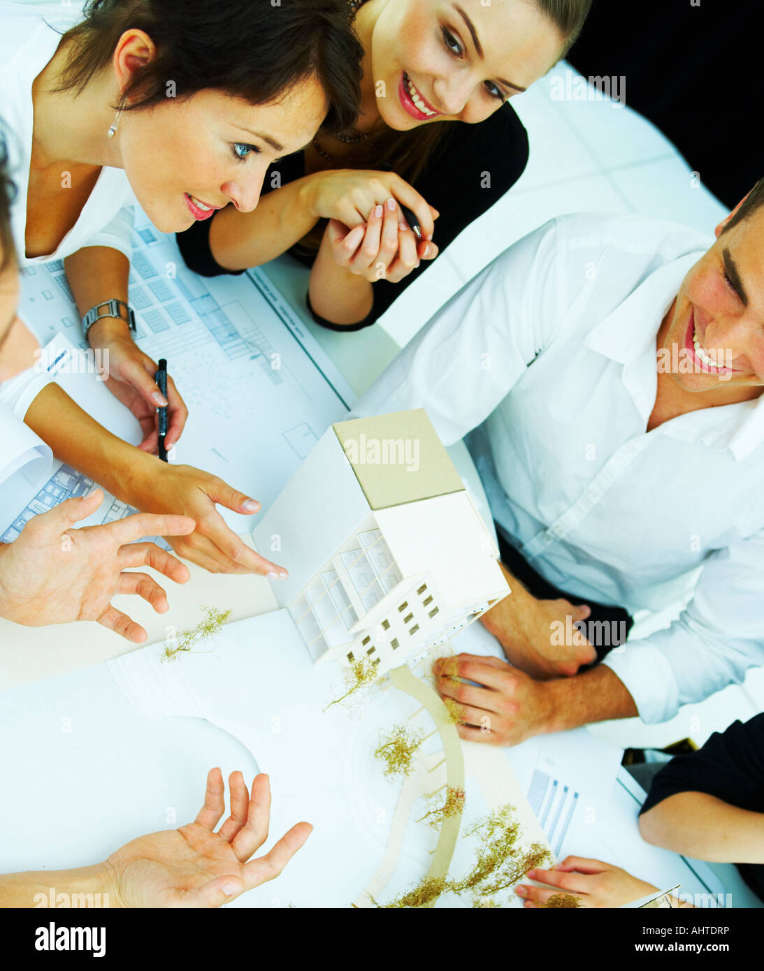 A group of young architects discussing the plans for a new building ...