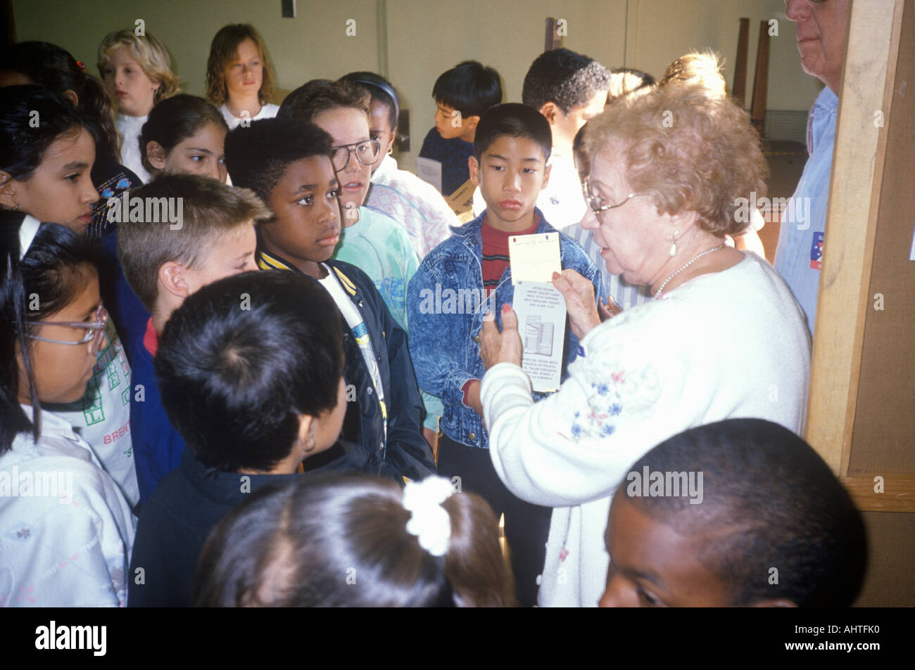 Election volunteers instructing young people on voting procedures in a ...
