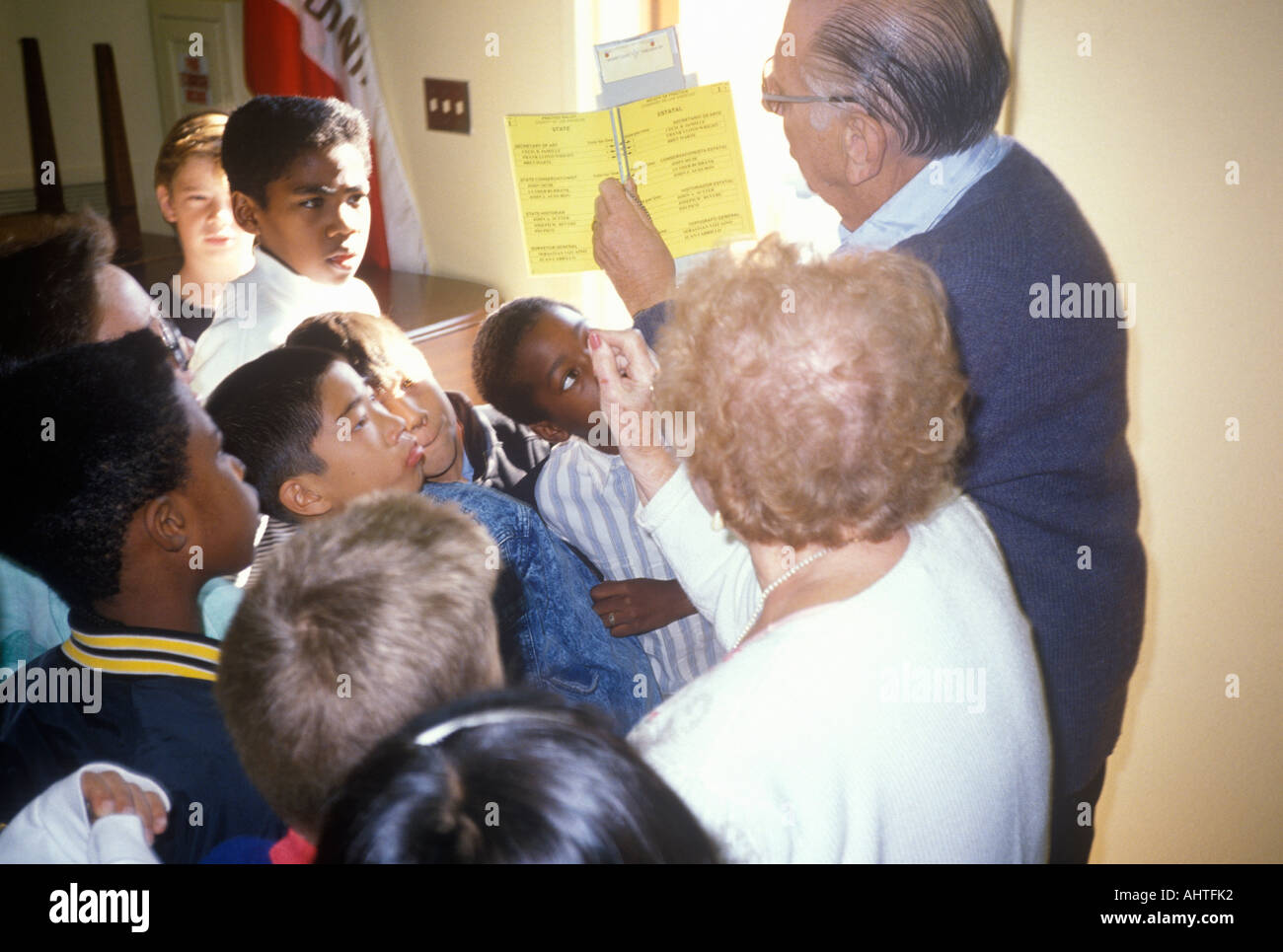 Election volunteers instructing young people on voting procedures in a ...
