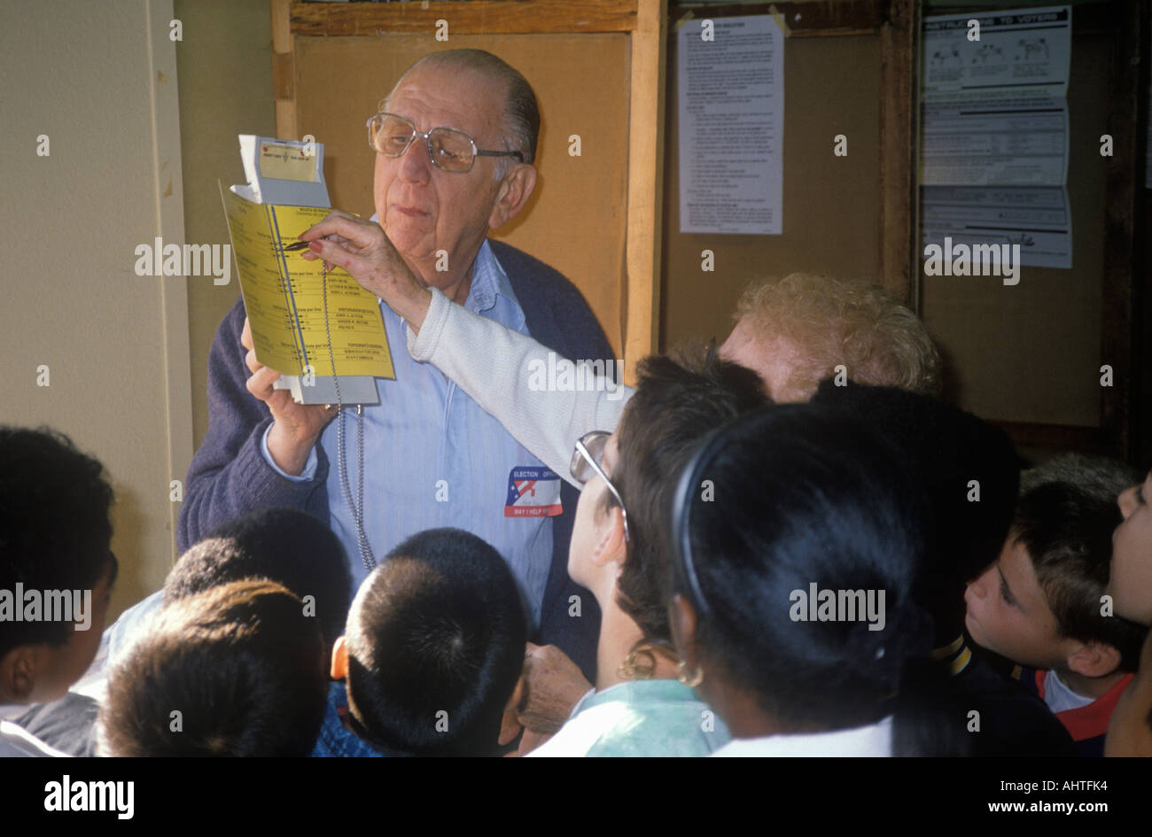 Election volunteers instructing young people on voting procedures in a ...