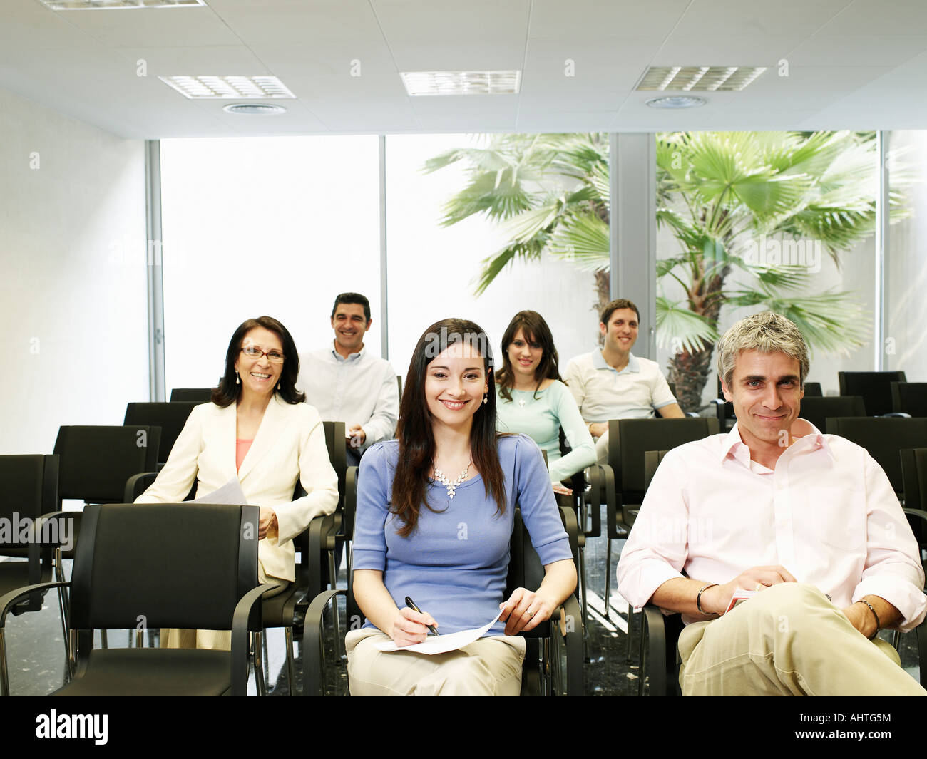 Colleagues watching presentation, smiling, portrait Stock Photo - Alamy