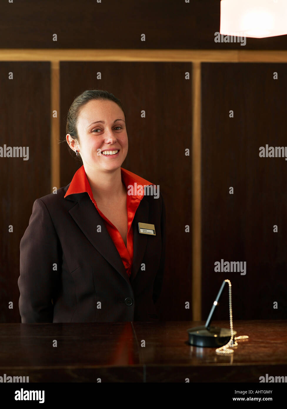 Young female hotel receptionist, smiling, portrait Stock Photo - Alamy