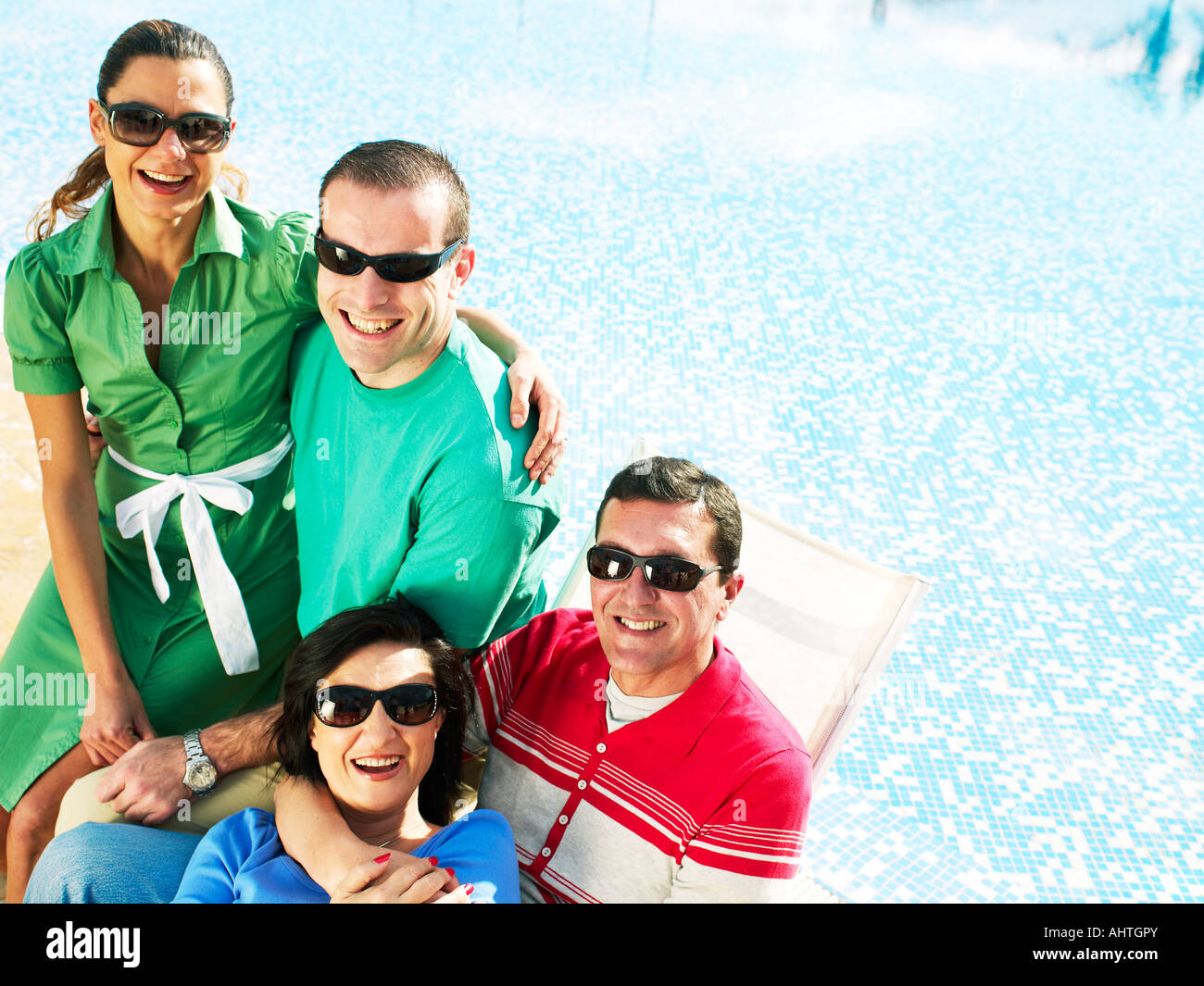Two couples sitting by swimming pool hi-res stock photography and ...
