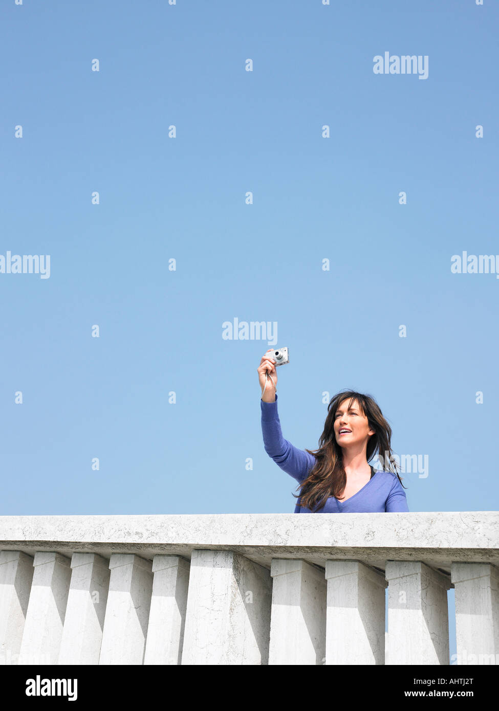 Woman on balcony taking photograph with digital camera venice hi-res ...