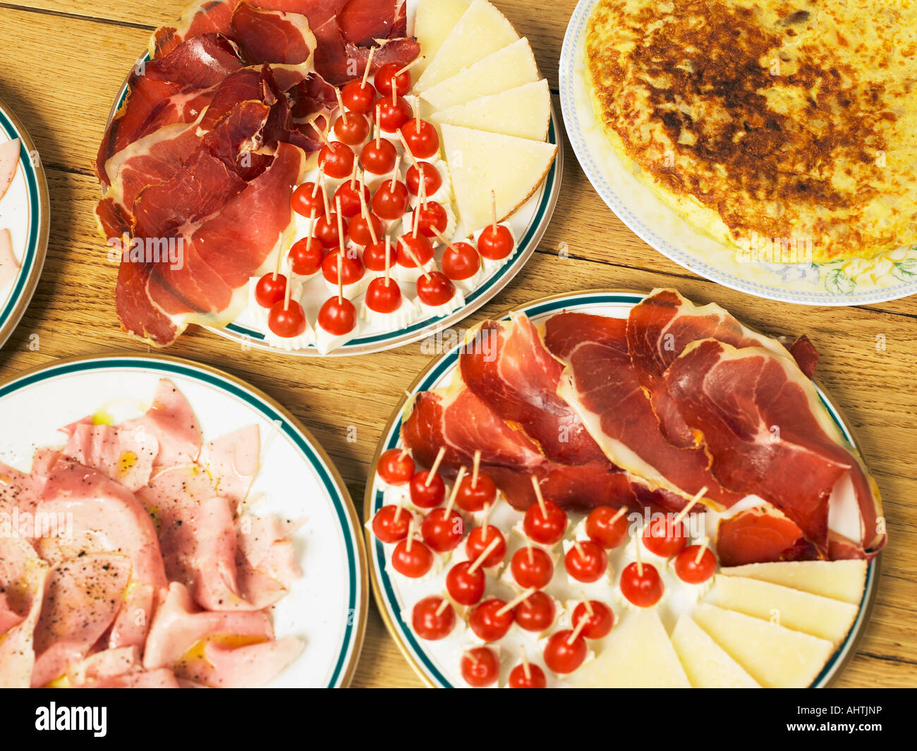Plates of cooked meat, cheese and tortilla on dining table Stock Photo ...