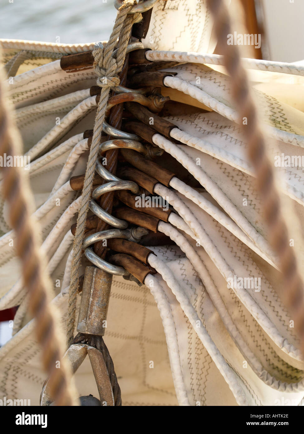 vertical closeup shot of lowered sail with metal rings and ropes on a ...