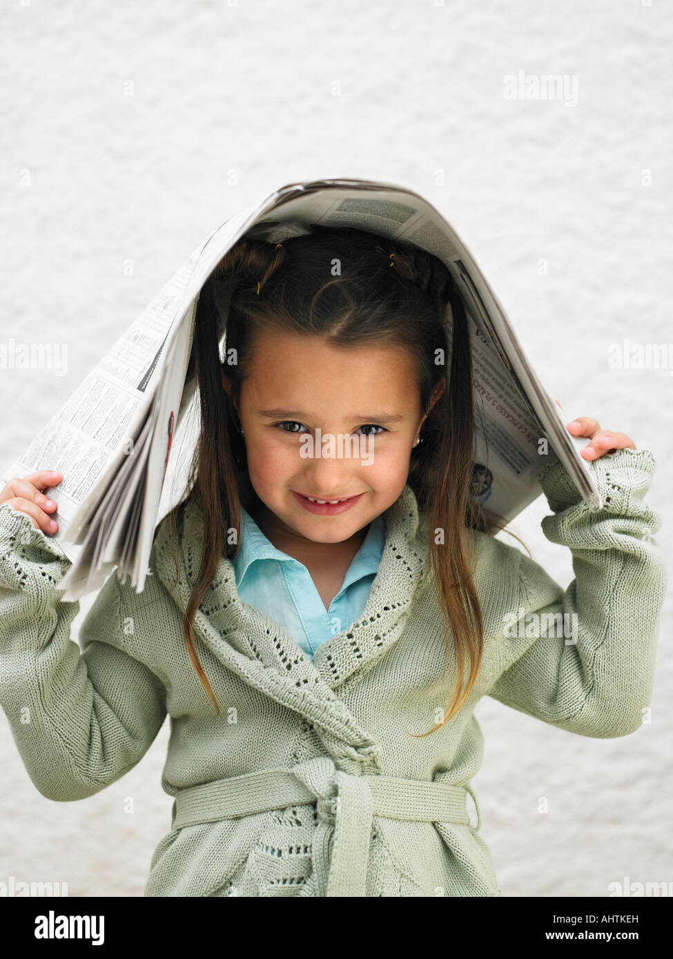 Young girl (4-6) holding a newspaper over head,portrait Stock Photo - Alamy