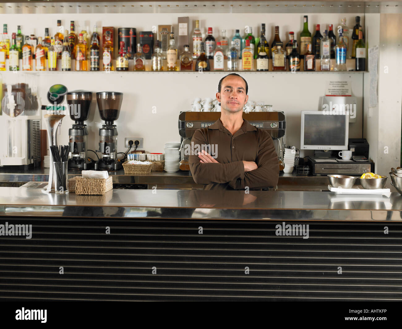 Barista with arms folded standing behind the counter in café. Alicante ...